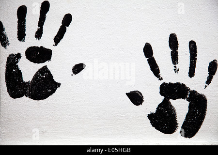 Black handprints on a white wall Stock Photo - Alamy