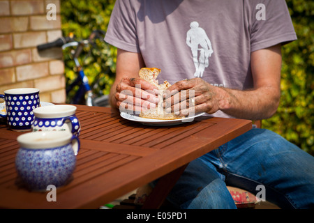 Man eating sandwich with dirty hands Stock Photo - Alamy