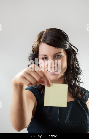 Beautiful woman with reminder sticker paper on forehead over isolated ...