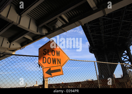 Slow down road sign, arrow on blue sky background. One way blank road ...