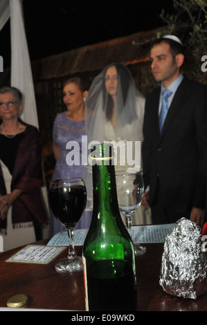 Jewish couple at marriage ceremony under a floral chuppa wedding canopy ...