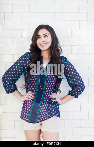 Smiling woman with hands on hip standing at home Stock Photo - Alamy