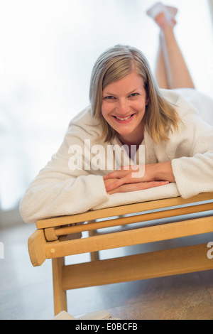 Woman lying on a spa bed, receiving a cosmetic body wrap treatment on ...