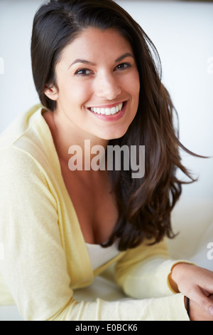 Smiling woman sitting on sofa at home Stock Photo - Alamy
