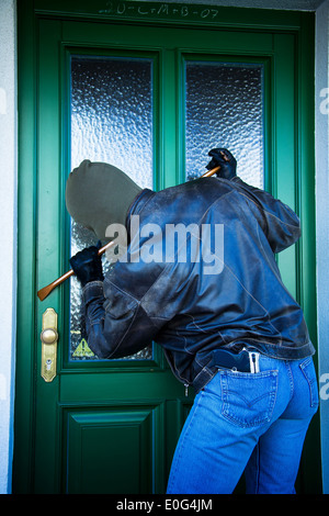 Armed thief breaking a door Stock Photo - Alamy