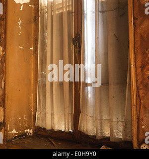 Old net curtains at a shuttered window in abandoned post office, Mwandi ...