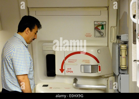 male muslim passenger on board an emirates flight prays towards mecca ...
