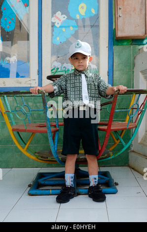 little indonesian schoolboy proudly posing in his school uniform in a ...