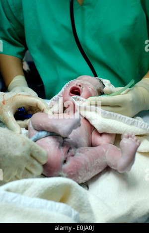 doctors and surgeons assist newborn baby to take first breath during ...