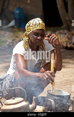 Kavango woman preparing the traditional maize flour dish Ugali or Pap ...