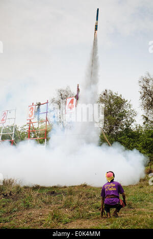 Yasothon, Thailand. 11th May, 2014. A Buddhist monk looks up as a ...