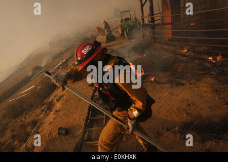 San Marcos, California, USA. 14th May, 2014. Firefighters work to save ...