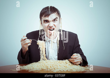 Gluttony and consumerism concept. Greedy businessman eating pasta Stock ...
