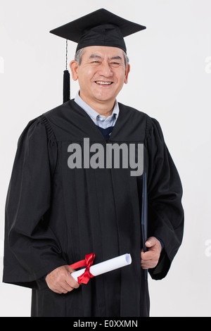 An old man in a graduation gown walks outdoors and holds a diploma ...