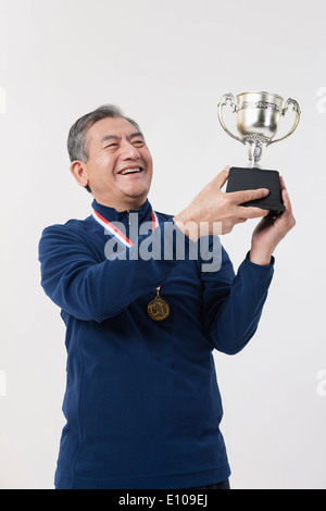 an old man posing with a medal and a trophy Stock Photo - Alamy