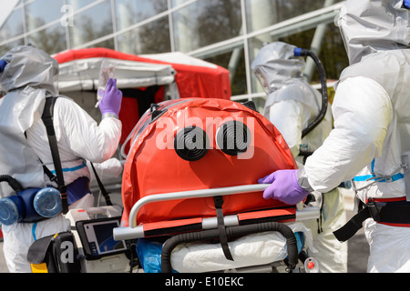 Biohazard team pushing stretcher towards chamber Stock Photo - Alamy