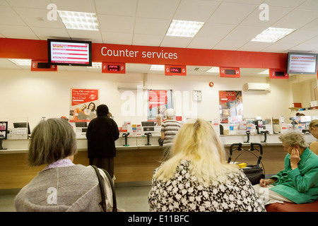 Post Office counter UK; People at the counter inside an English Post ...