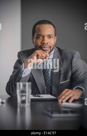 Mixed race businessman sitting in server room Stock Photo - Alamy
