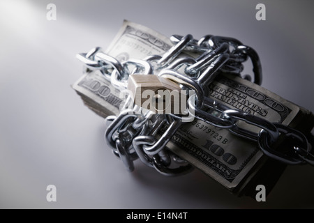 Chains and padlock around stack of dollar bills Stock Photo - Alamy