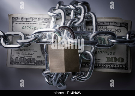 Chains and padlock around stack of dollar bills Stock Photo - Alamy