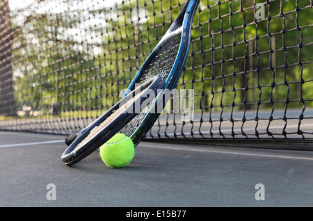 Two tennis rackets leaning against wall next to a pool, accompanied by ...
