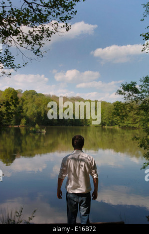 A Teenage Man,Standing At The Edge Of A Freshwater Lake Stock Photo - Alamy