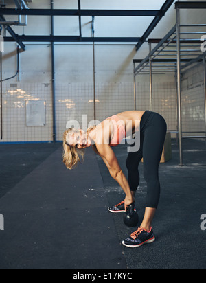 Strong crossfit woman exercising with a kettlebell at the gym. Female ...