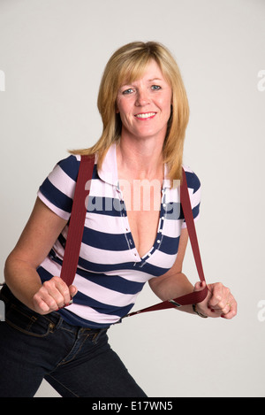 Portrait of woman wearing striped T-shirt putting physical bitcoin into ...