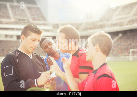 Soccer players arguing with referee on field Stock Photo - Alamy