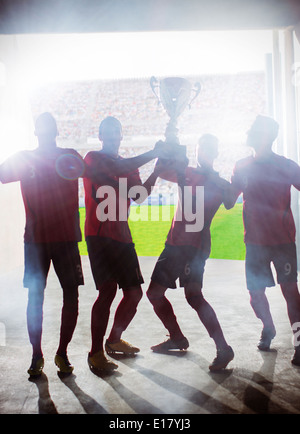 Young Soccer Players Holding Trophy. Boys Celebrating Soccer Football Championship. Winning team ...