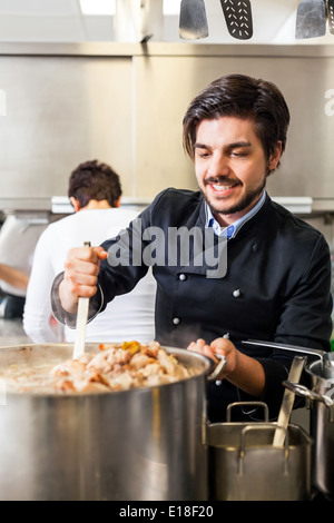 Attractive friendly chef preparing food Stock Photo - Alamy