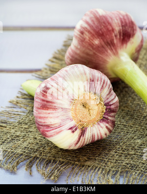 Bulbs of garlic on white rustic wood table Stock Photo - Alamy
