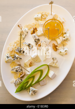 Tray with different types of cheese, honey, grapes and dried figs on ...
