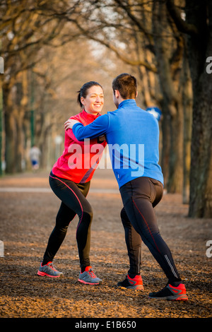 jogging couple warming up and stretching in the city Stock Photo - Alamy