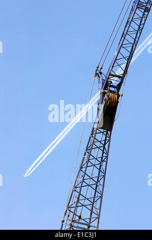 Crane and high flying jet plane in blue sky Stock Photo - Alamy