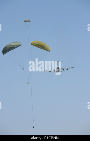 Two U.S. Air Force Airmen pull a squeegee to defuel the hose back into ...