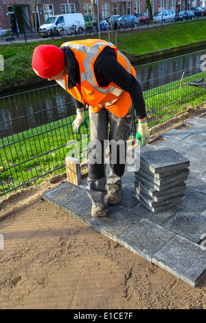 paviours at work in street in town Stock Photo - Alamy