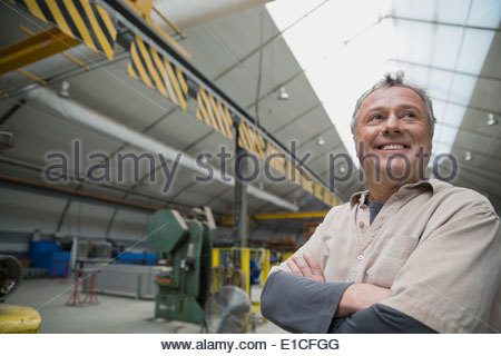 Worker smiling in manufacturing plant Stock Photo - Alamy