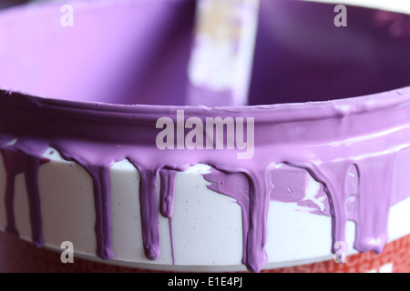 Purple paint bucket with mixing stick Stock Photo - Alamy