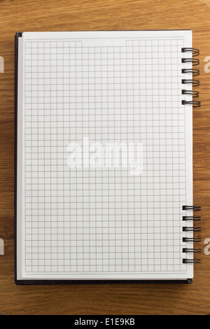 checked notebook on wood background Stock Photo - Alamy