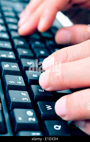 Hand of engineer typing on keyboard by tablet PC at desk in home office ...