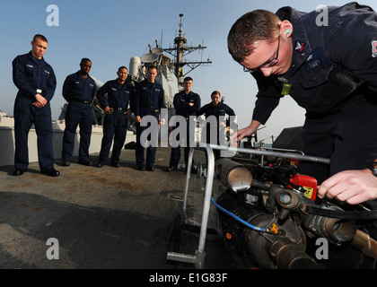 U.S. Navy Damage Controlman 1st Class Danny Valdivia refills self ...