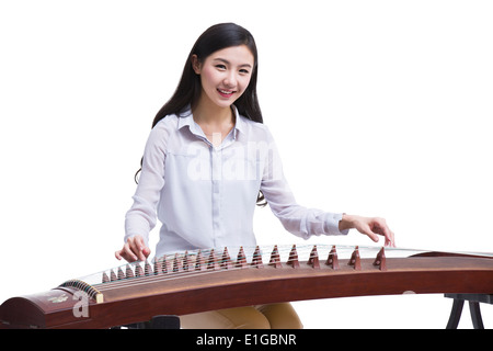 Chinese woman playing a guqin, a musical instrument also known as a ...