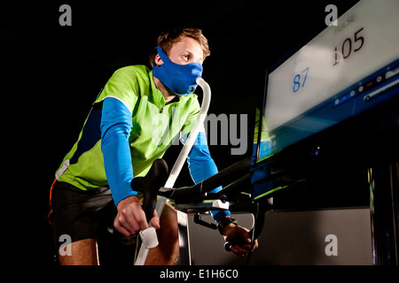 Young man in face mask using laptop and staring happy at camera ...