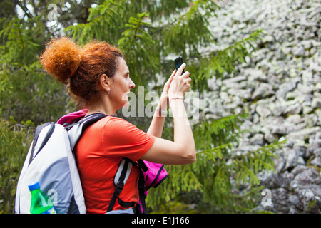Beautiful redhead woman with backpack and mobile phone taking selfie on ...
