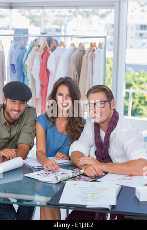 Three fashion designers looking at sketchpad Stock Photo - Alamy