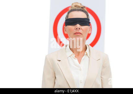 Businesswoman blindfolded and target behind Stock Photo - Alamy