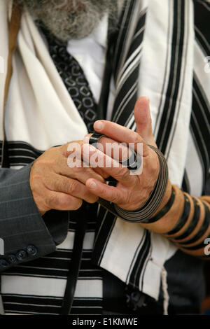 Religious Jewish man putting on phylacteries - teffilin - at morning ...