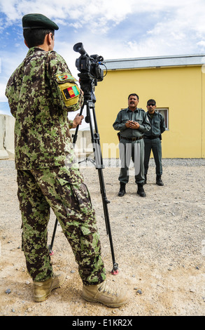 An Afghan National Police officer, left, speaks with an Afghan Local ...