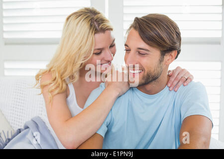 Cute casual couple sitting on couch under blanket Stock Photo - Alamy